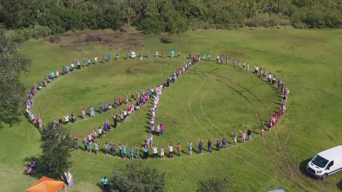 More than 120 people form giant human peace sign at event in St ...