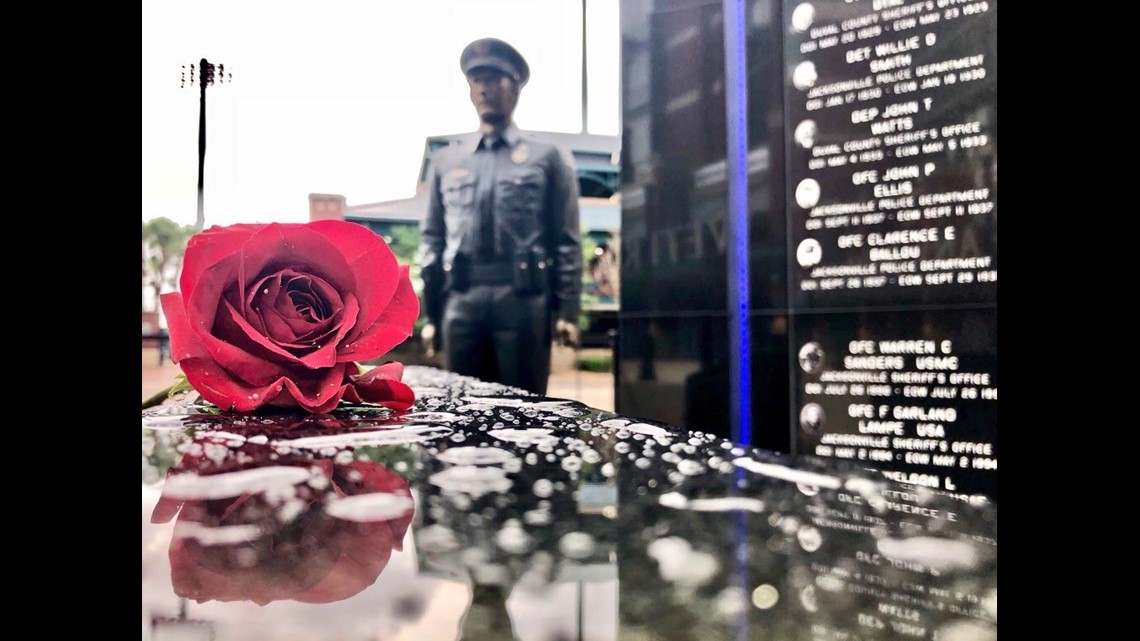 Flowers and prayers at fallen officer memorial wall | firstcoastnews.com